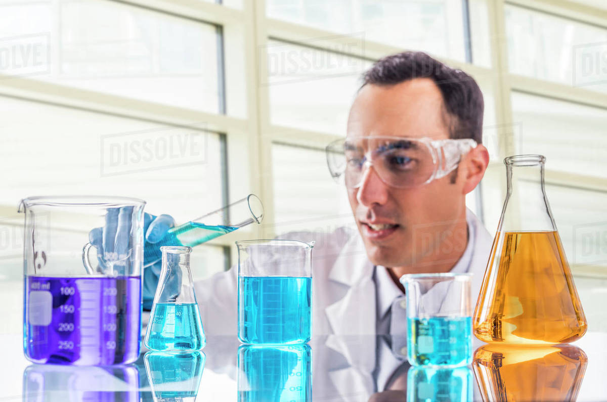 Scientist pouring blue liquid in laboratory - Royalty-free Stock Photo ...