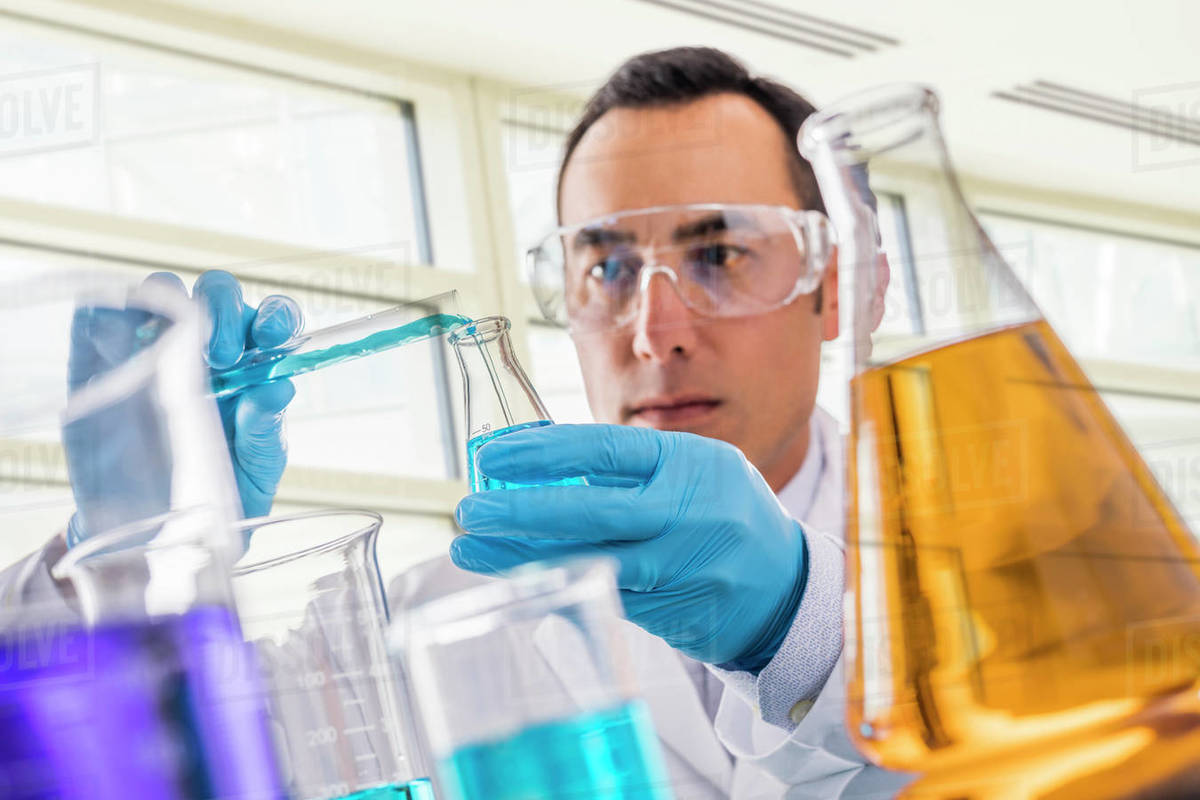 Scientist pouring blue liquid in laboratory - Royalty-free Stock Photo ...