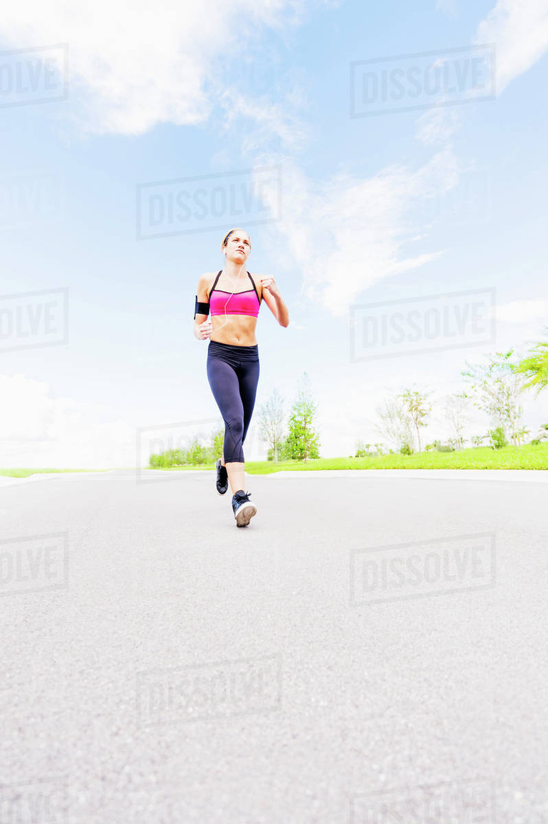 Young woman jogging in park - Royalty-free Stock Photo | Dissolve