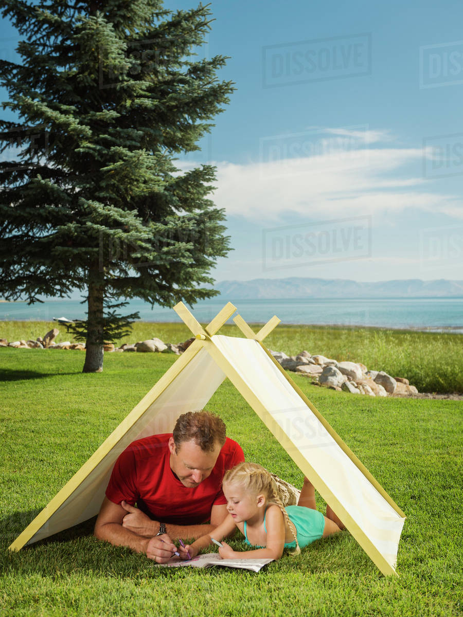 Father and daughter (2-3) playing in tent - Stock Photo - Dissolve
