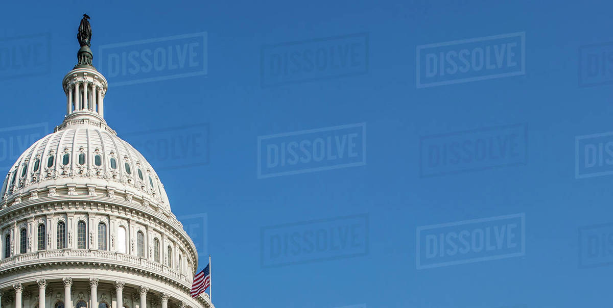 USA, Washington D.C., USA Capital building with flag against blue sky ...
