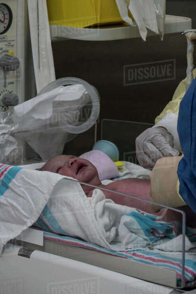 Doctors with crying newborn baby girl (0-1 months) in hospital ...