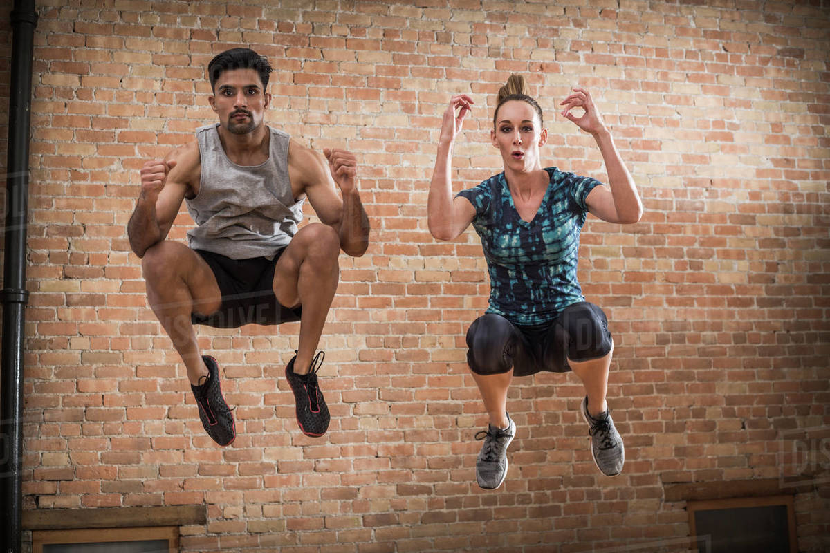 Man and woman jumping in gym - Royalty-free Stock Photo | Dissolve
