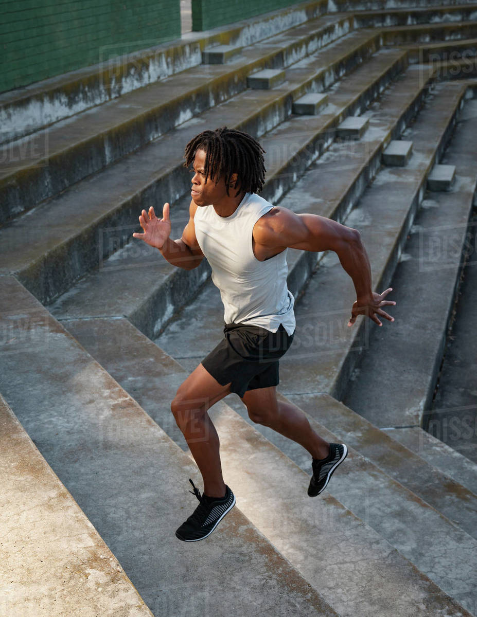 Athletic man running up steps - Royalty-free Stock Photo | Dissolve
