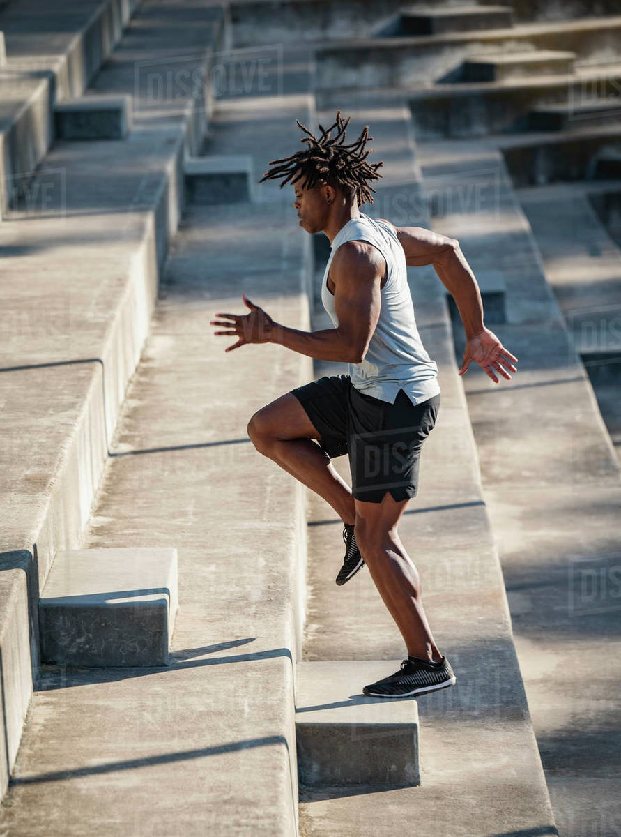 Athletic man running up steps - Royalty-free Stock Photo | Dissolve
