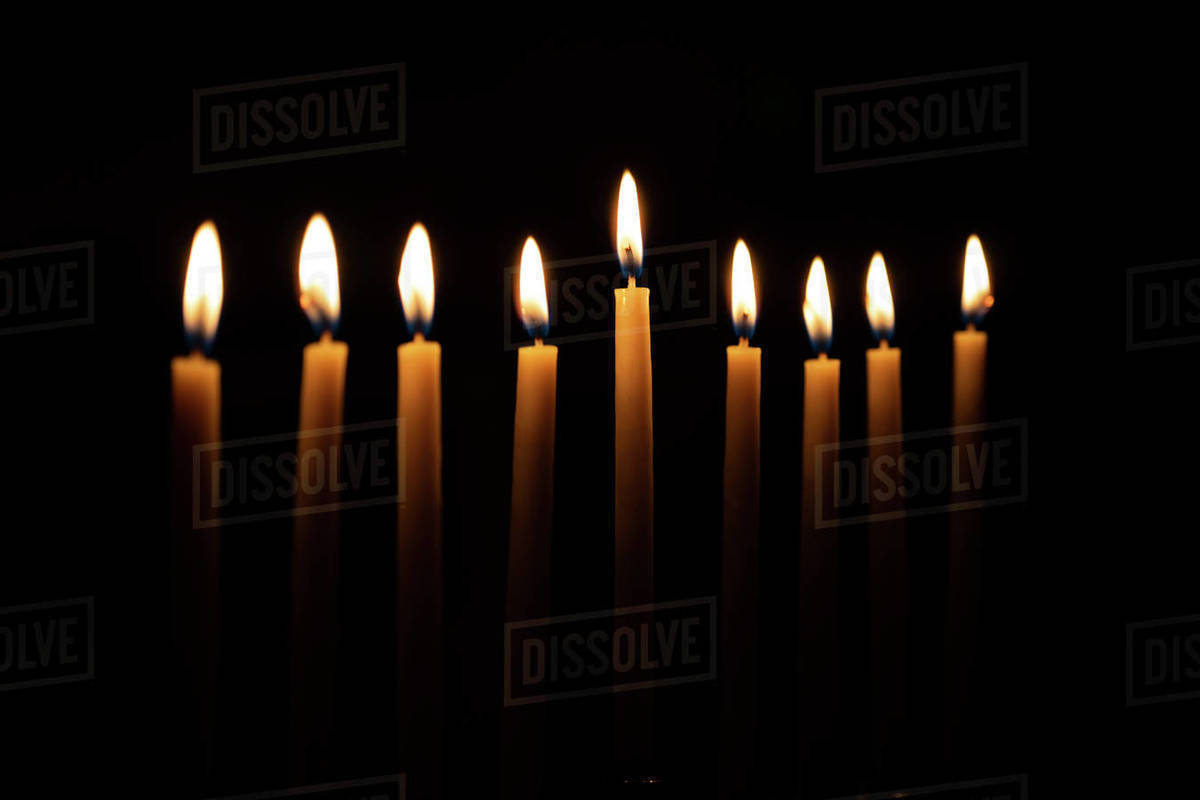 Row of candles against black background - Stock Photo - Dissolve