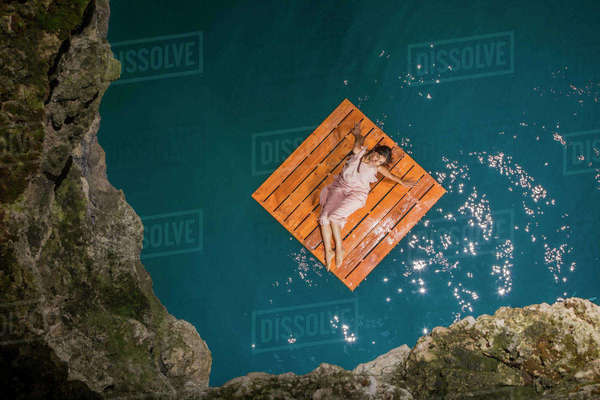 Aerial view of woman lying on wooden raft - Royalty-free Stock Photo ...