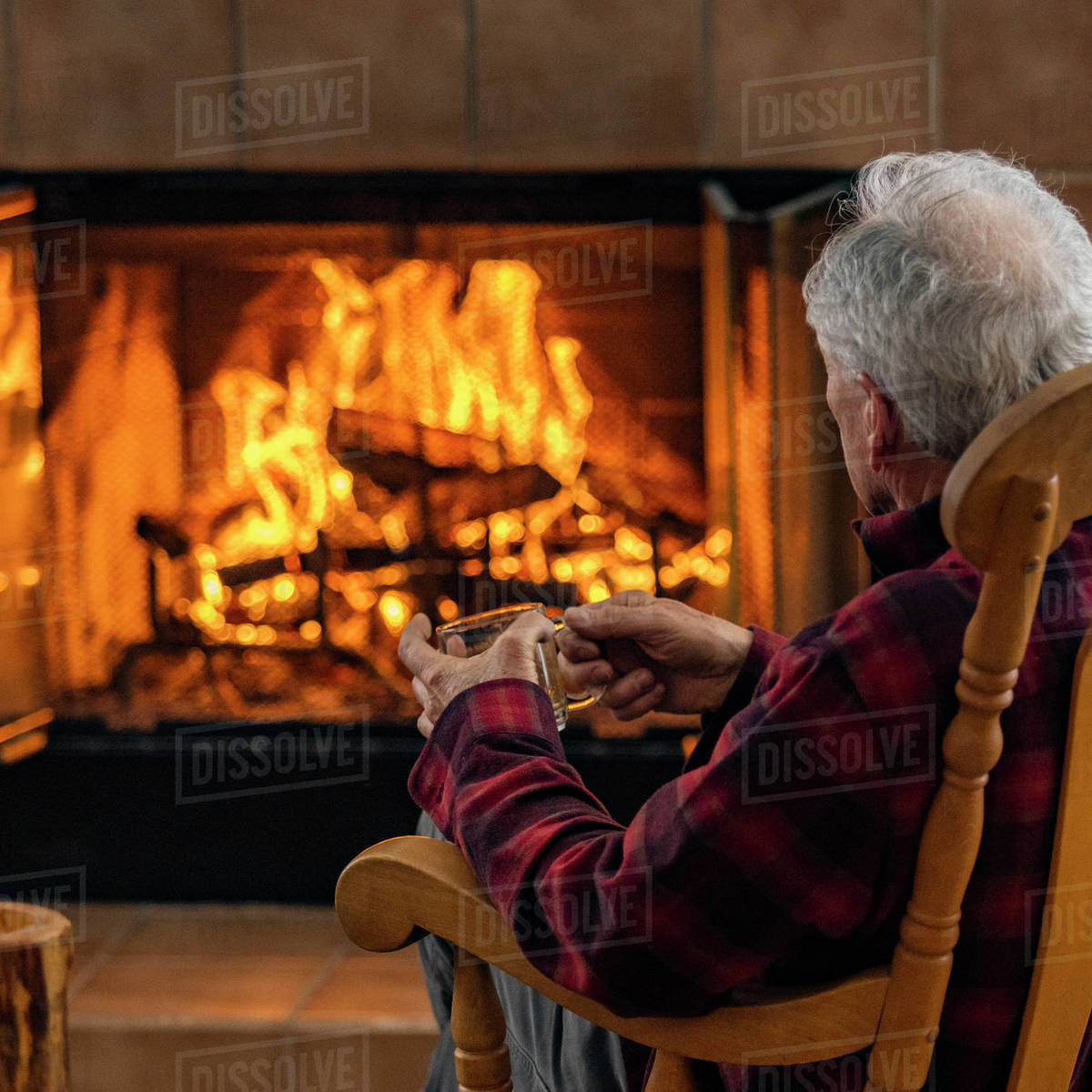 Senior man relaxing in front of wood burning fireplace - Royalty-free ...