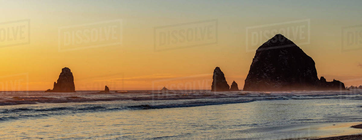 USA, Oregon, Silhouette of Haystack Rock at Cannon Beach at sunset ...