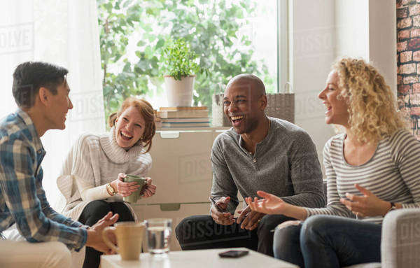 Friends hanging out in living room - Royalty-free Stock Photo | Dissolve