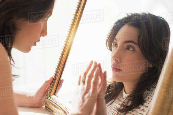 Serious young woman looking into mirror - Royalty-free Stock Photo ...