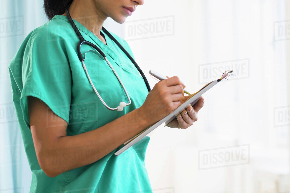 Female doctor making notes - Royalty-free Stock Photo | Dissolve