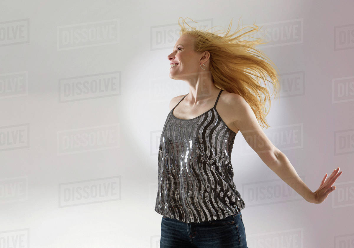 Happy woman dancing in studio - Stock Photo - Dissolve