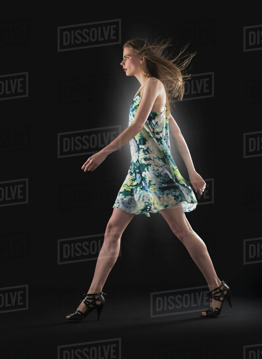 Studio shot of young woman walking - Royalty-free Stock Photo | Dissolve