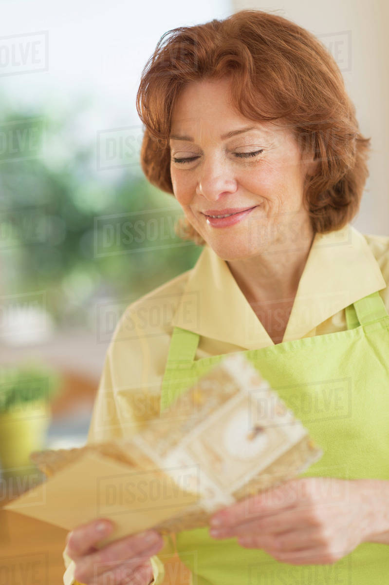 Senior woman reading greeting card - Royalty-free Stock Photo | Dissolve