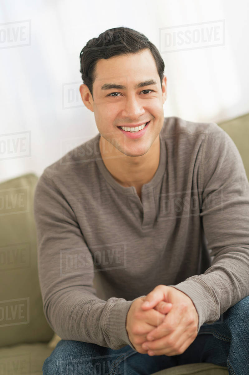 Portrait of smiling man sitting on sofa - Royalty-free Stock Photo ...