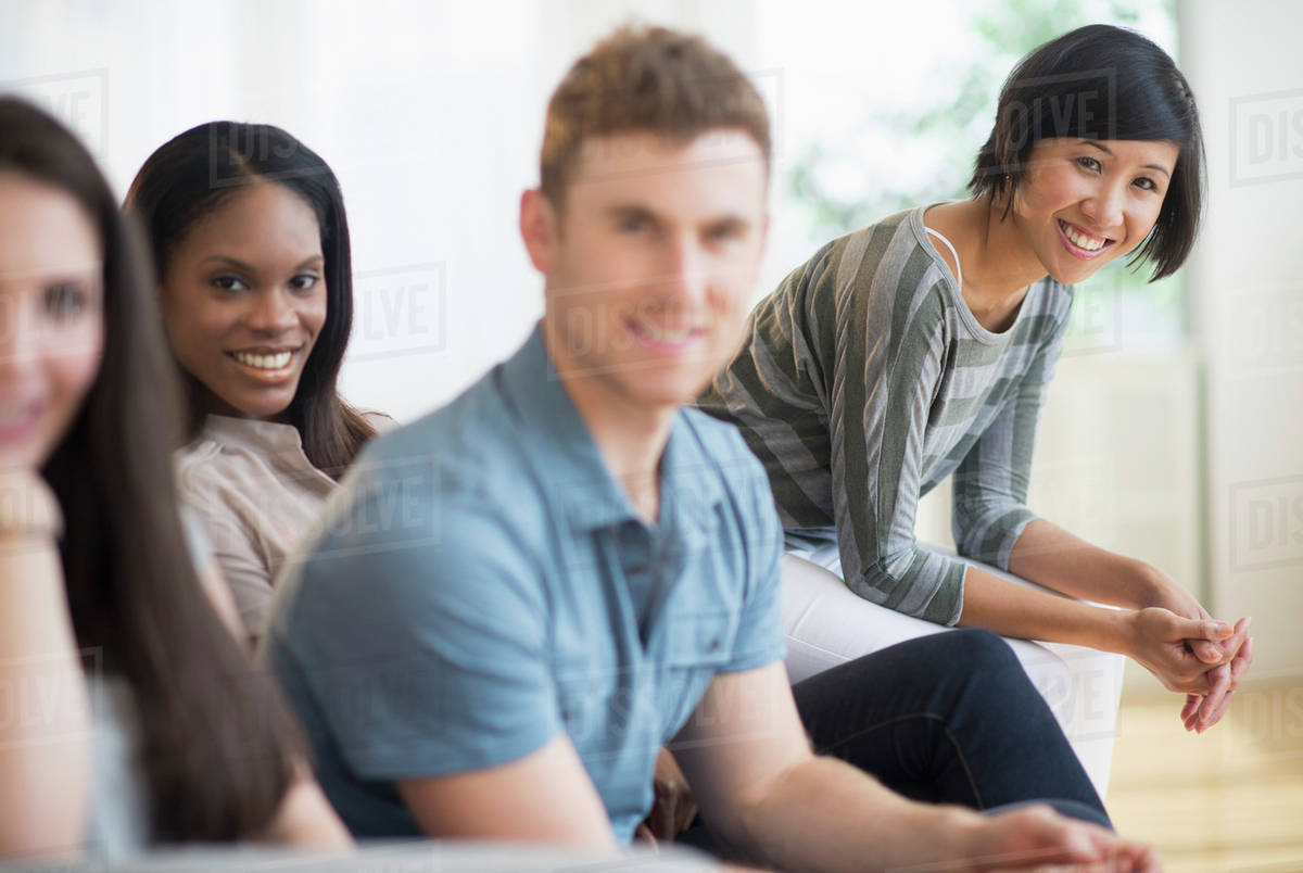 Friends sitting on sofa - Royalty-free Stock Photo | Dissolve