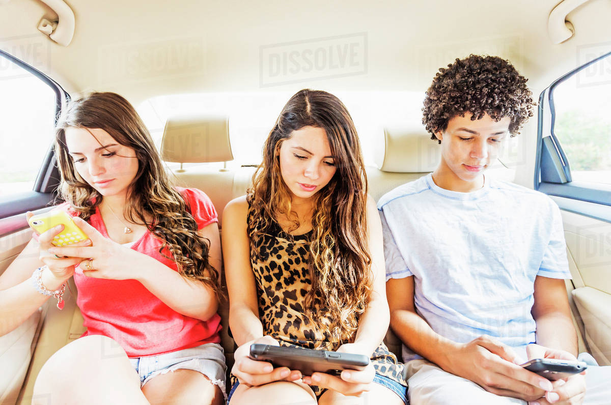 Young people and teenager (14-15) using cell phones in car - Royalty ...