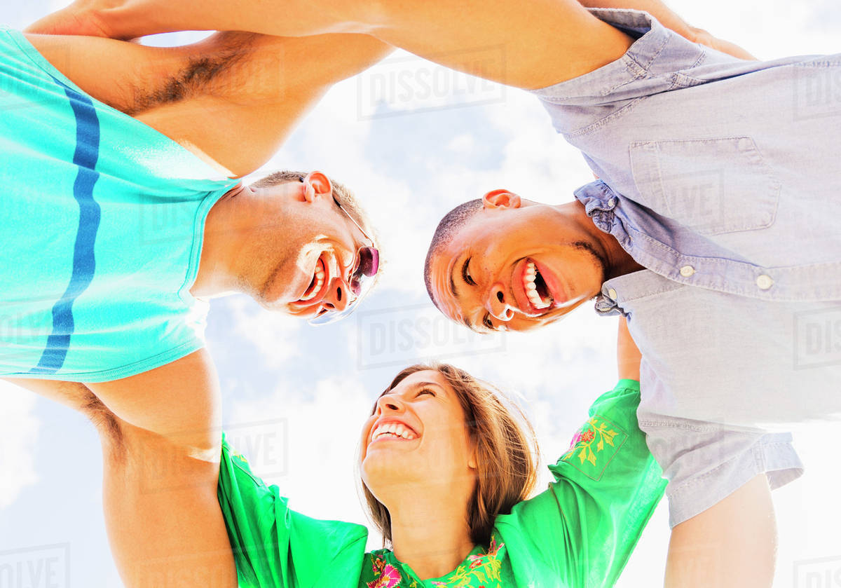 Young people with arms around each other - Stock Photo - Dissolve