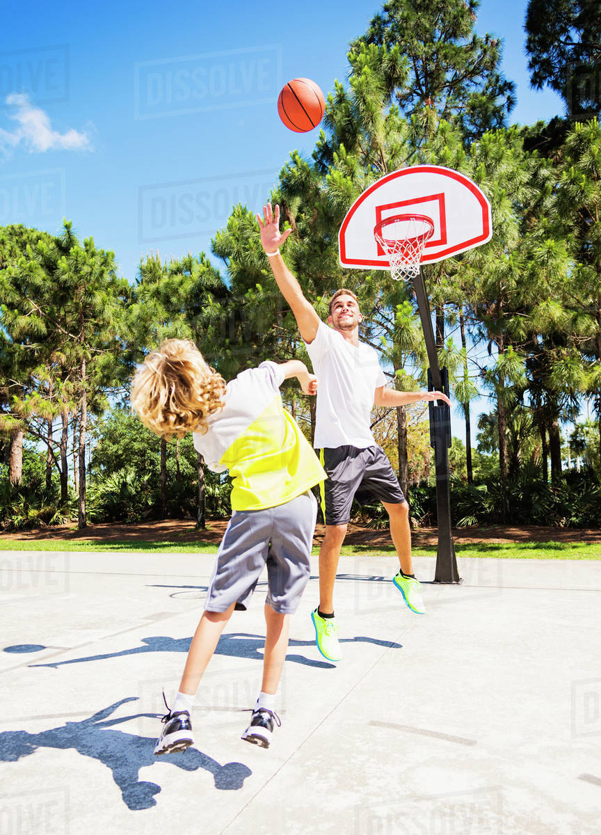 Boy (8-9) playing basketball with his brother - Royalty-free Stock ...