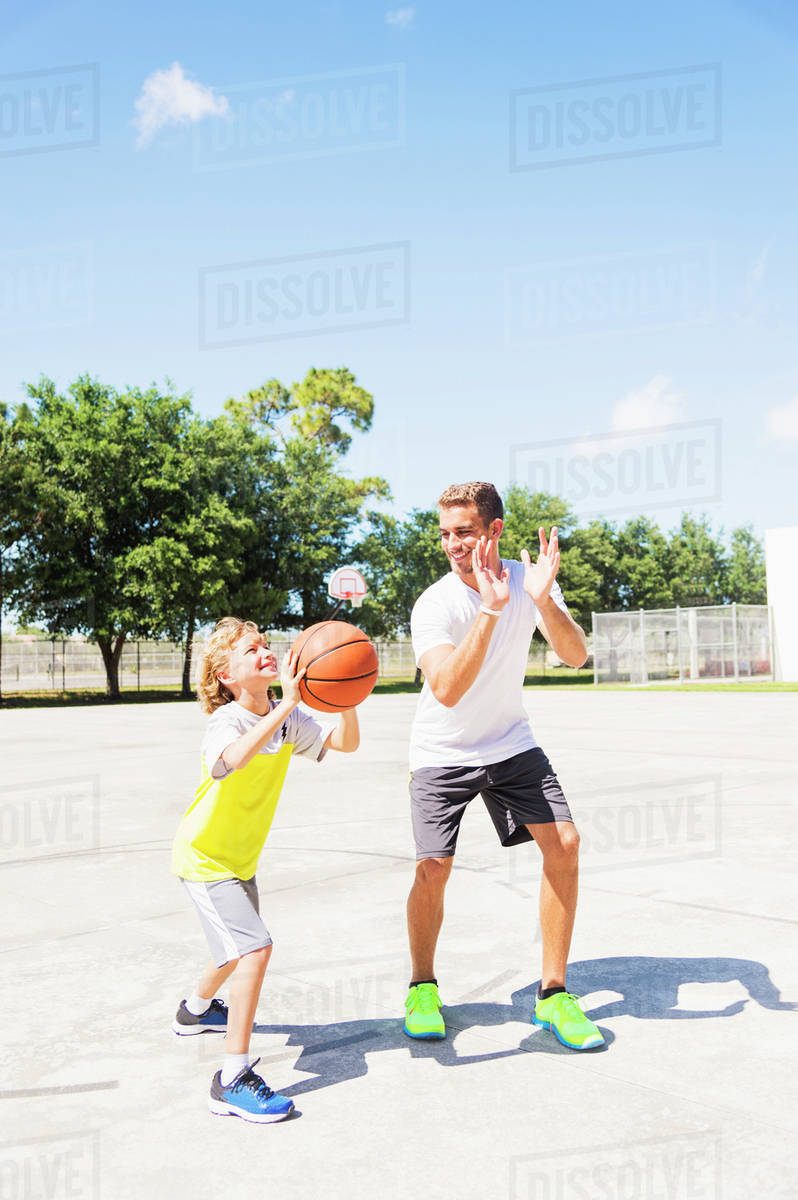 Boy (8-9) playing basketball with his brother - Royalty-free Stock ...