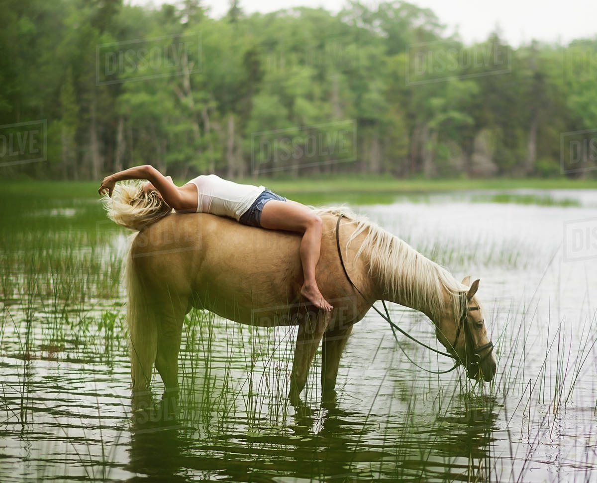 Woman horseback riding in countryside - Royalty-free Stock Photo | Dissolve