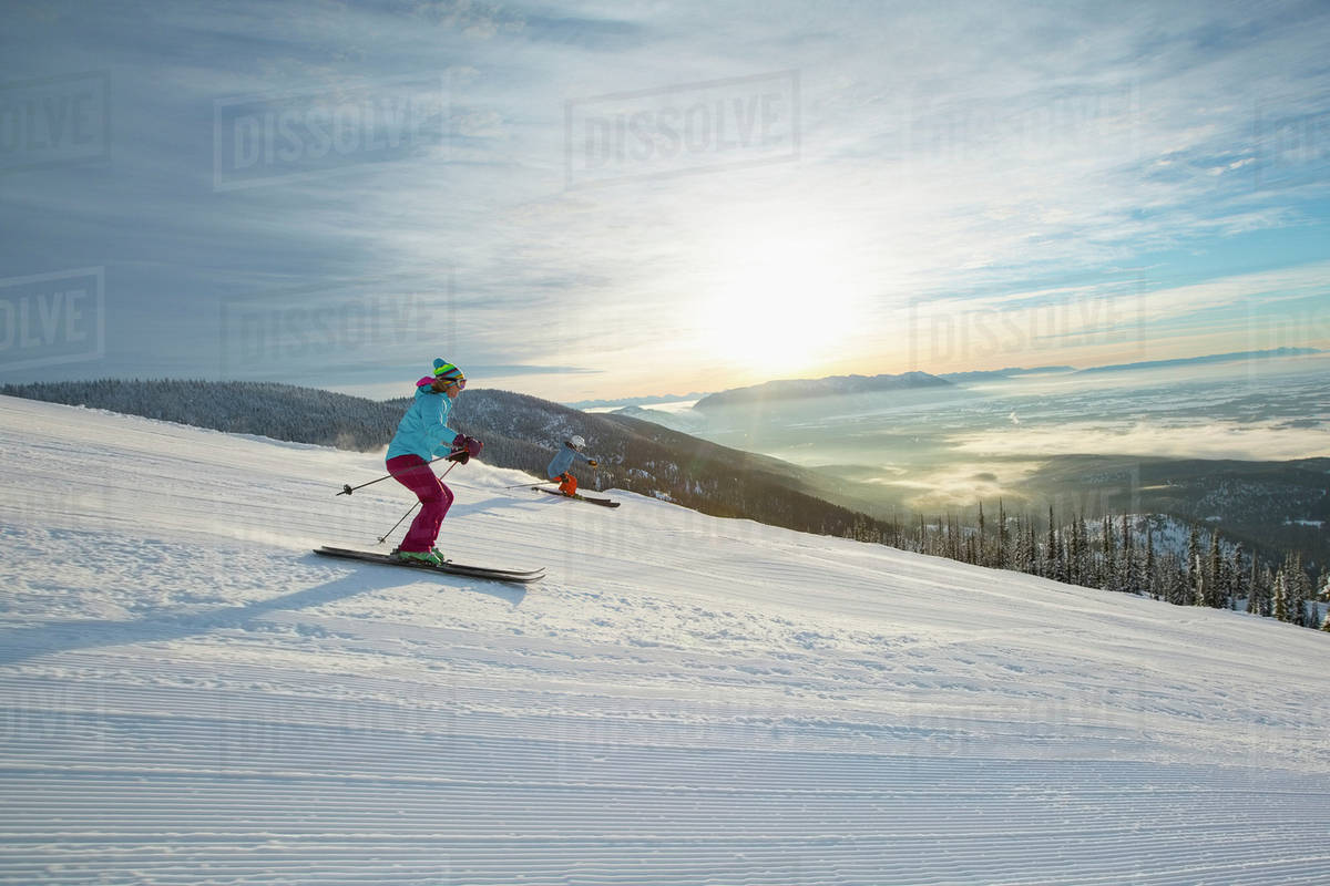 Couple skiing at sunset - Stock Photo - Dissolve