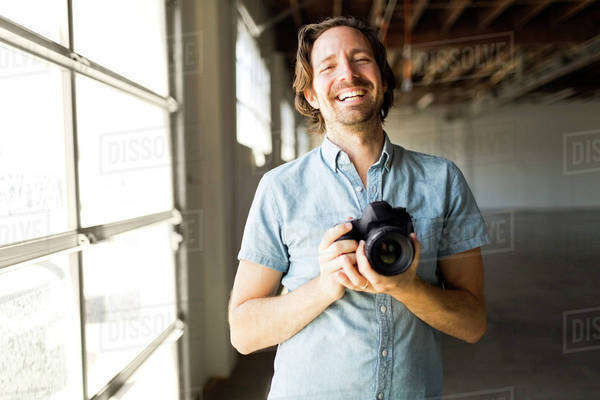 Smiling man with digital camera - Royalty-free Stock Photo | Dissolve