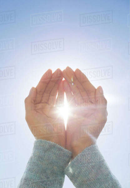Female hands against clear sky, sun shining through fingers - Royalty ...