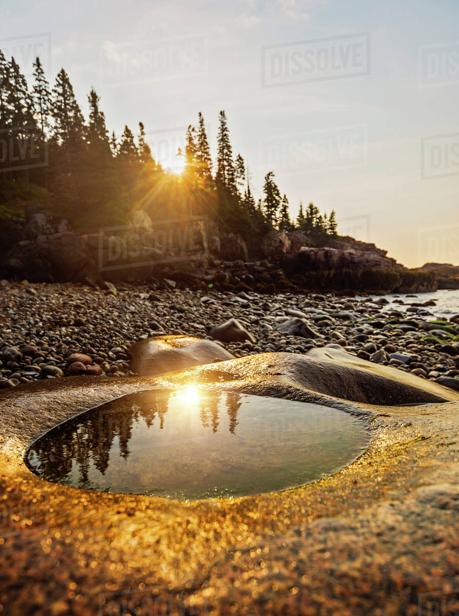 Rocks and pebbles on beach at sunrise - Royalty-free Stock Photo | Dissolve