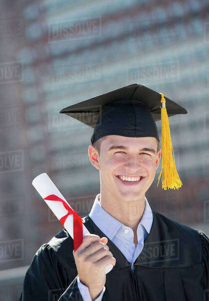 Teenage boy (16-17) at his graduation ceremony - Stock Photo - Dissolve