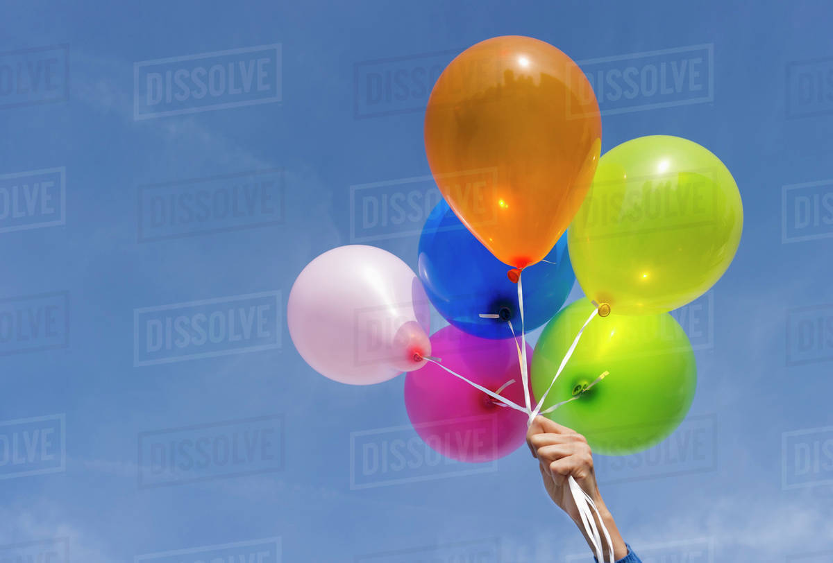 Woman's hand holding balloons - Royalty-free Stock Photo | Dissolve