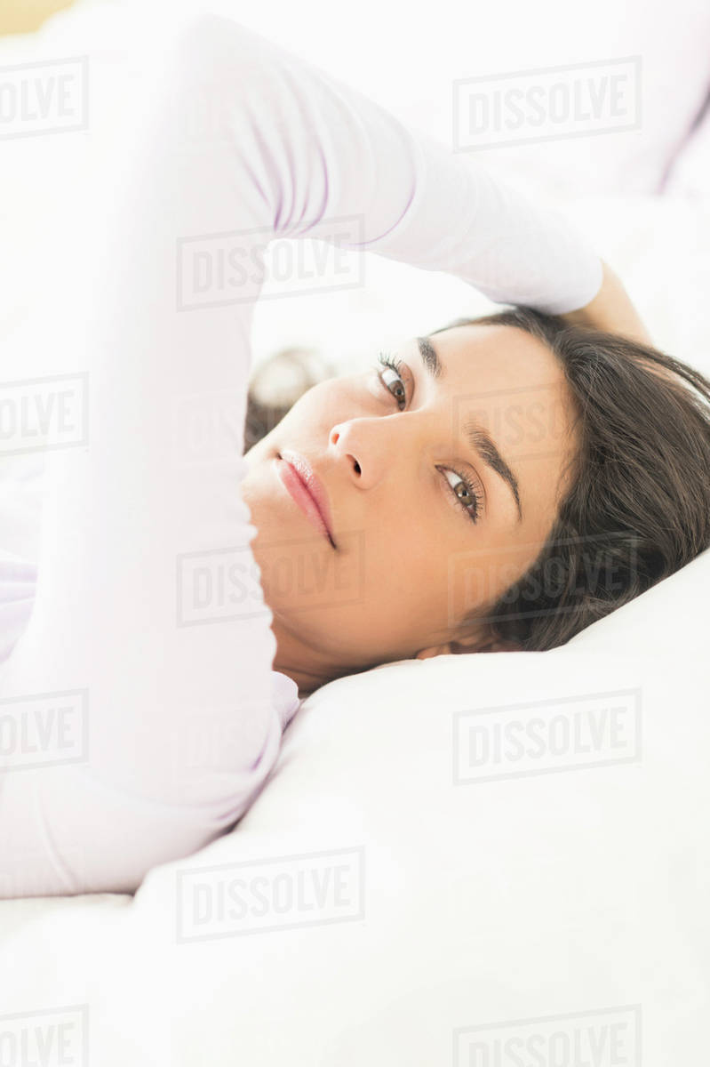 Portrait of woman lying in bed - Royalty-free Stock Photo | Dissolve