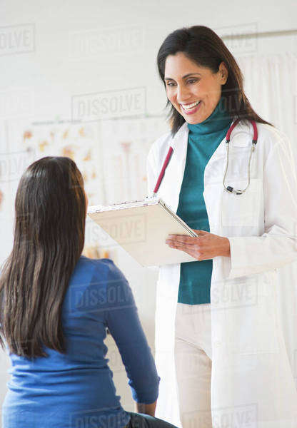 Doctor and patient (12-13) in doctor's office - Stock Photo - Dissolve