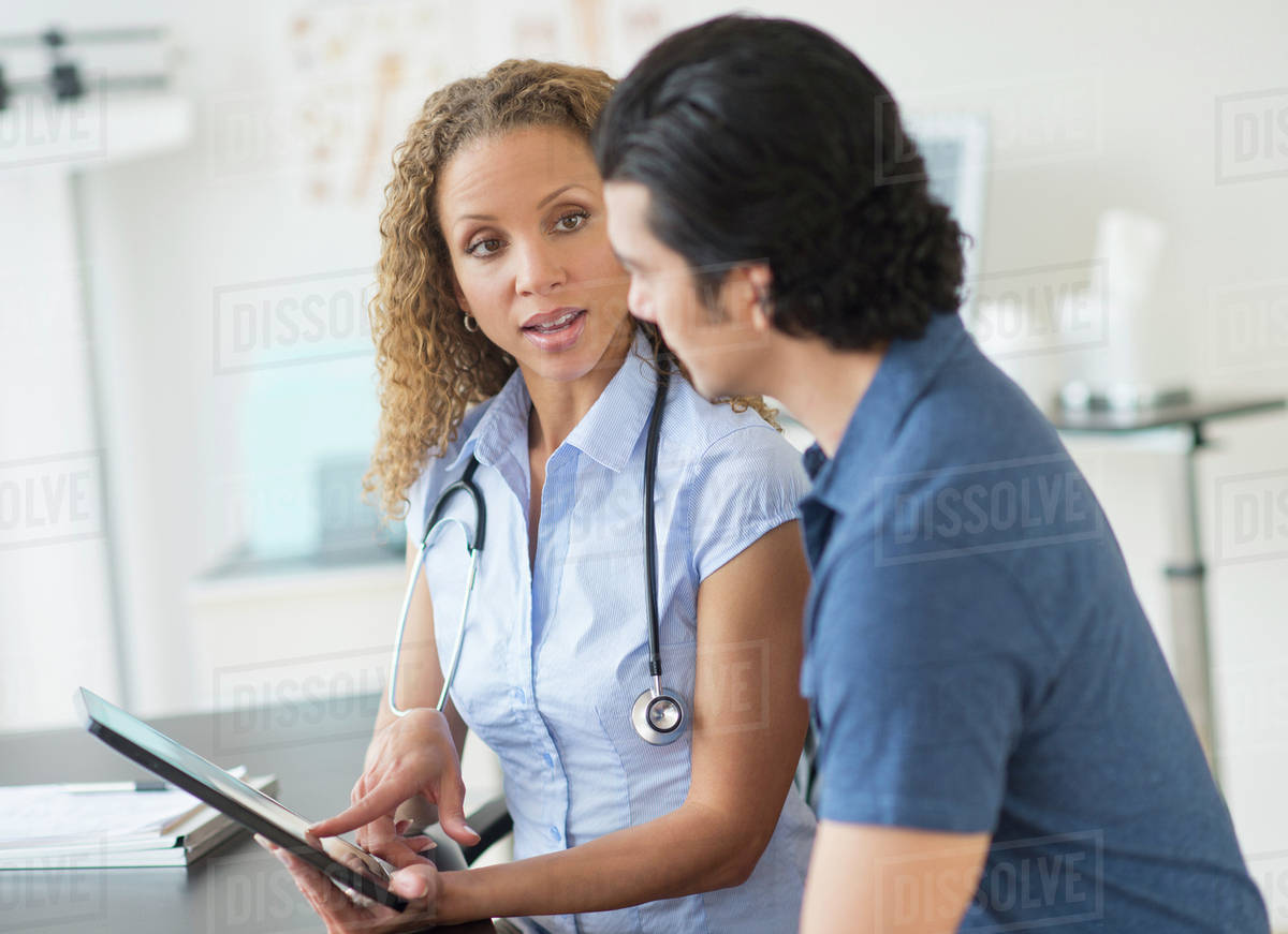 Doctor and patient talking in clinic using tablet pc - Royalty-free ...