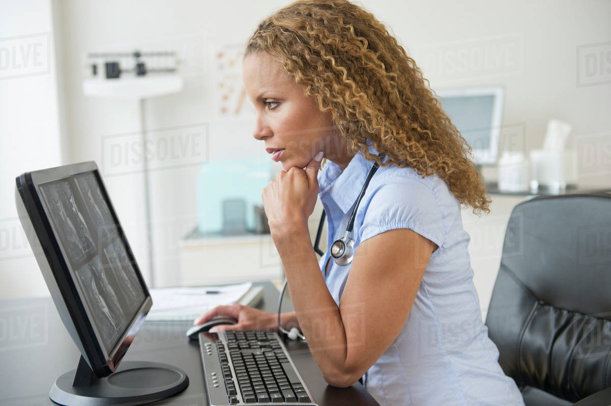 Doctor looking at computer - Stock Photo - Dissolve