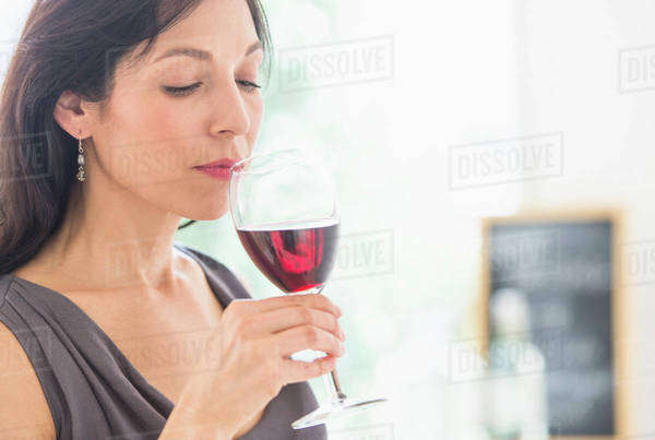 Woman tasting red wine - Stock Photo - Dissolve