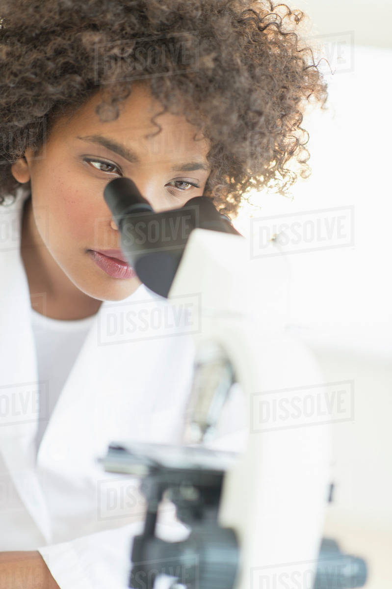 Woman using microscope in laboratory - Royalty-free Stock Photo | Dissolve