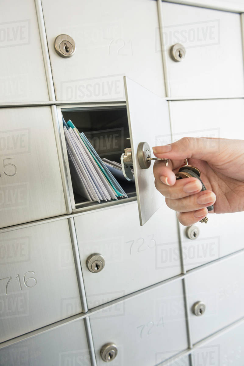 Woman closing safety deposit box - Stock Photo - Dissolve