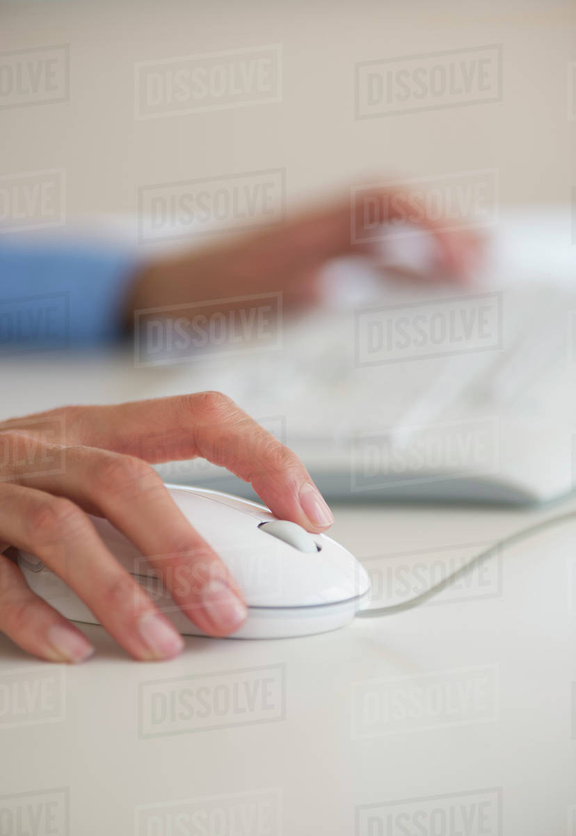 Human hand with computer mouse - Stock Photo - Dissolve
