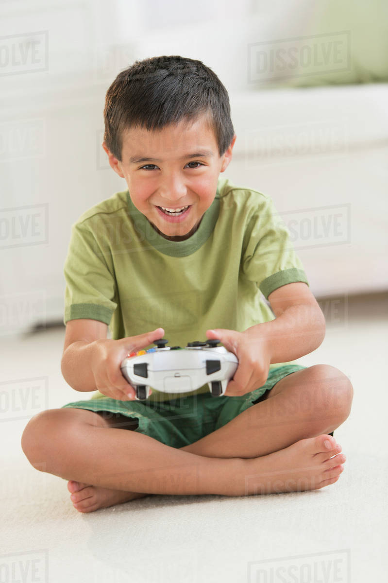 Boy (6-7) playing video game - Royalty-free Stock Photo | Dissolve