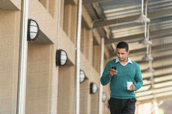 Man walking outside building and text messaging - Royalty-free Stock ...