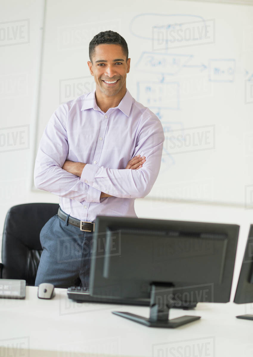 Portrait of male business executive at desk - Stock Photo - Dissolve