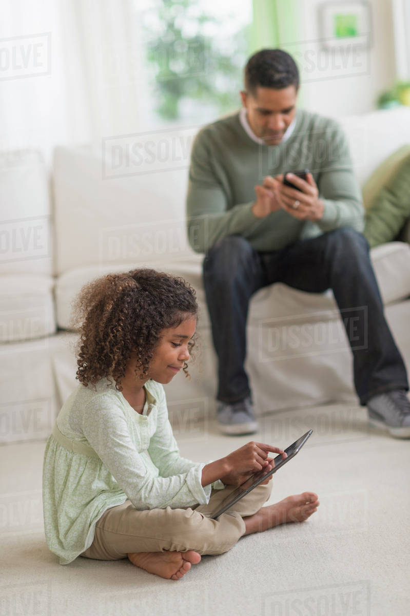 Father and daughter (6-7) using mobile phone and digital tablet - Stock ...