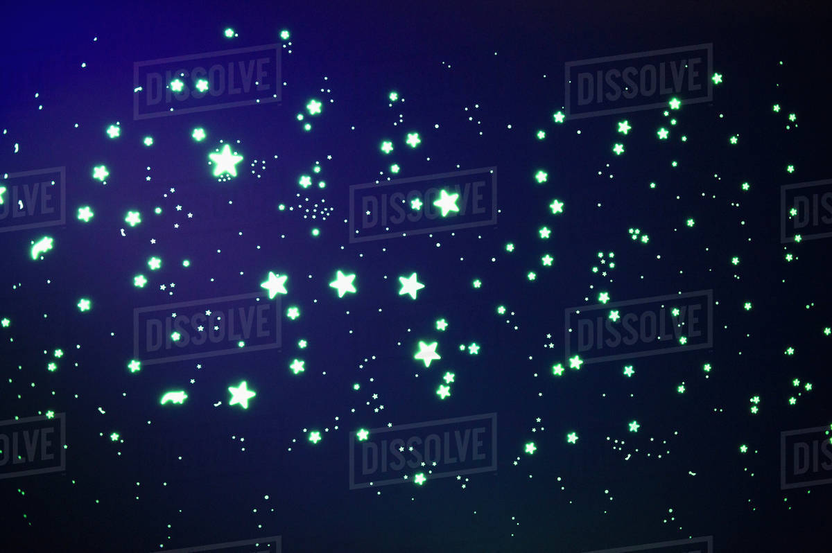 Fluorescent stars on blue background, studio shot - Stock Photo - Dissolve