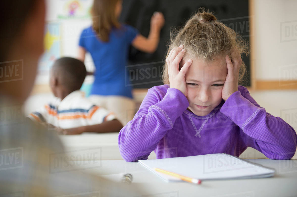 Schoolgirl (8-9) having problems while learning in classroom - Royalty ...
