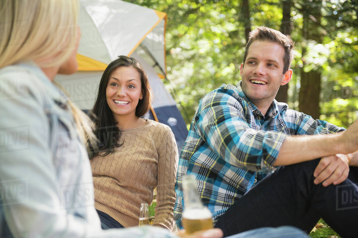 Three friends camping in forest - Stock Photo - Dissolve