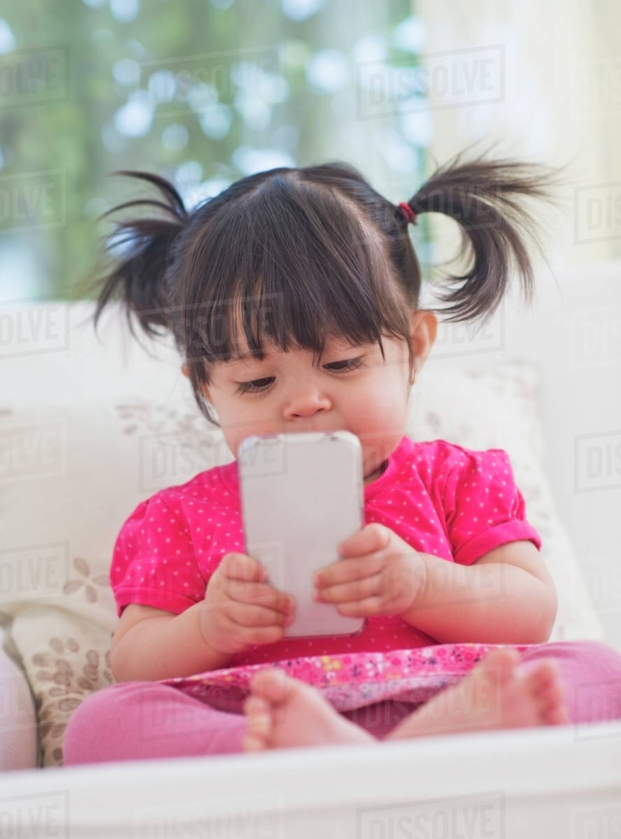 Baby girl (12-17 months) playing with mobile phone - Royalty-free Stock ...