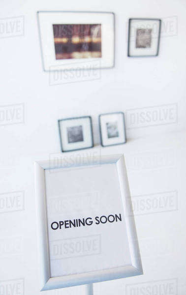 Opening sign with pictures on white wall in background - Stock Photo ...