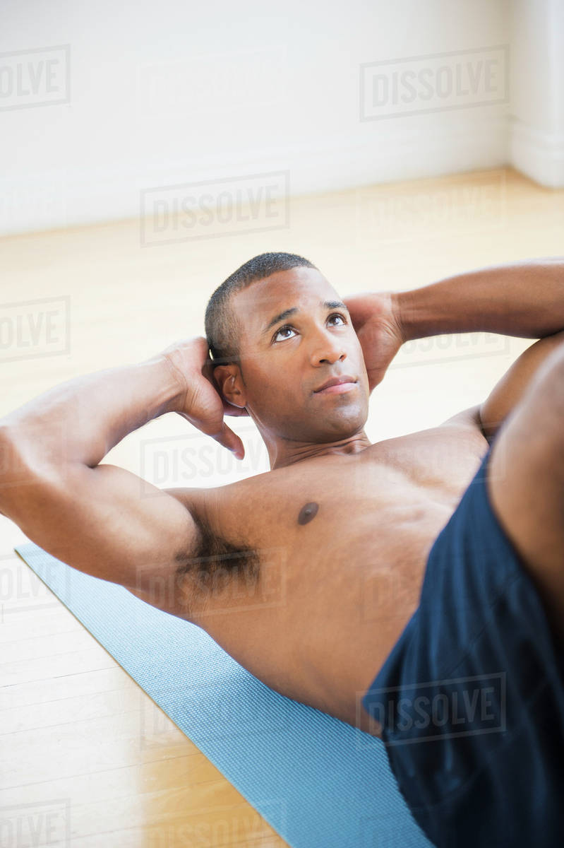 Athletic young man exercising - Stock Photo - Dissolve